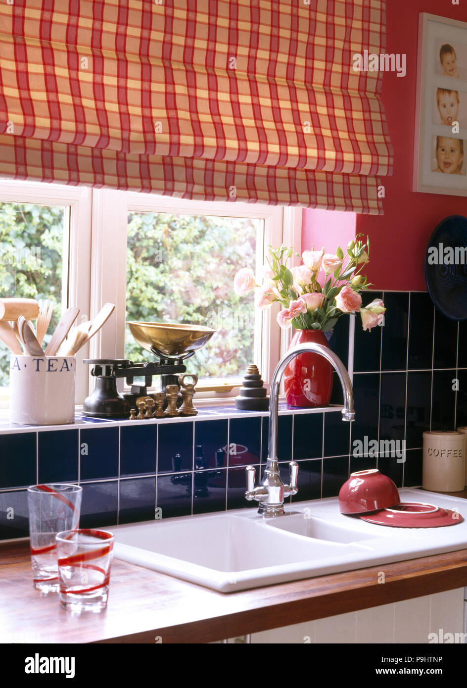 Red checked blind on window above sink in nineties kitchen with blue ...