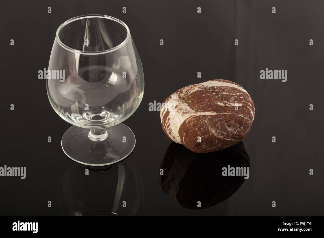 Natural stone and a glass on the varnished coating, the reflection of ...