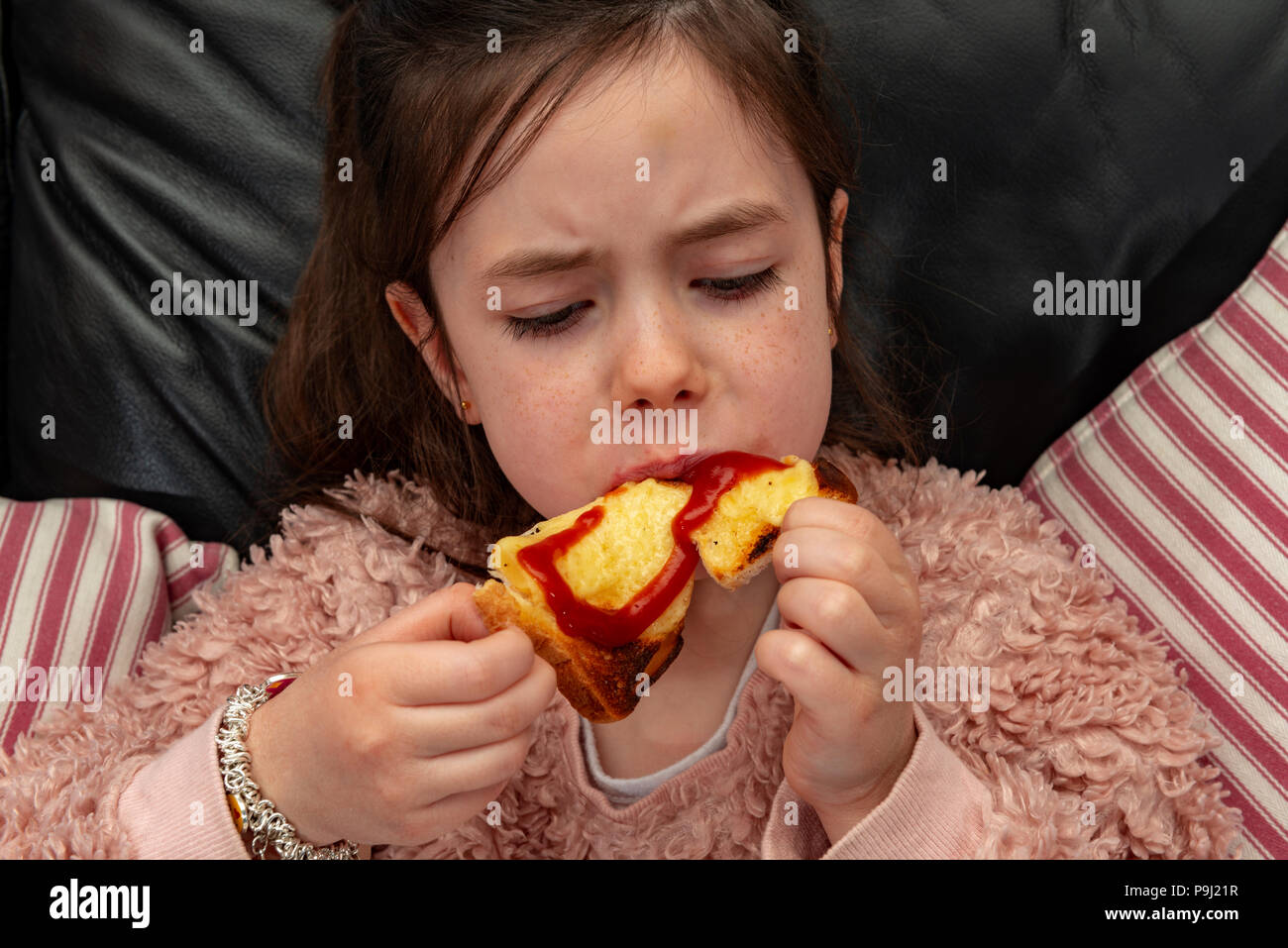 Young girl eating cheese on toast Stock Photo - Alamy