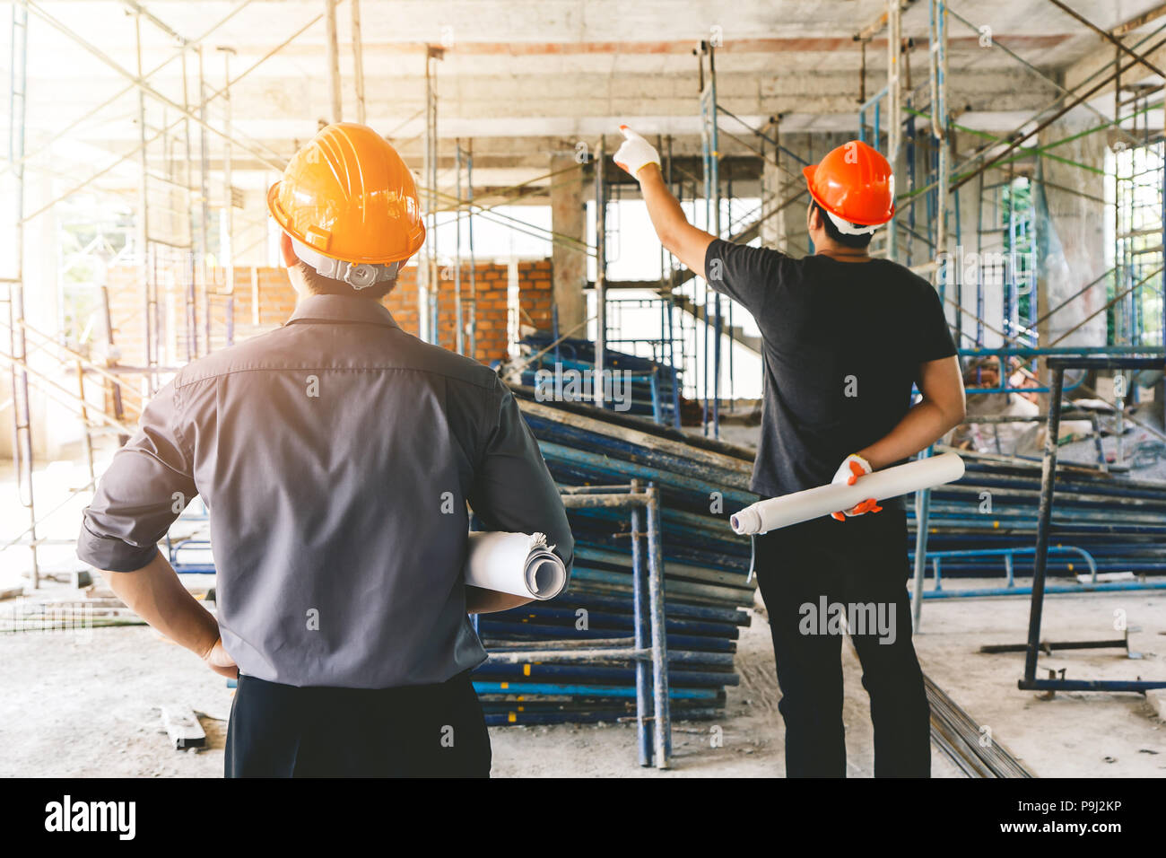 Engineer discussing with foreman about project in building construction ...