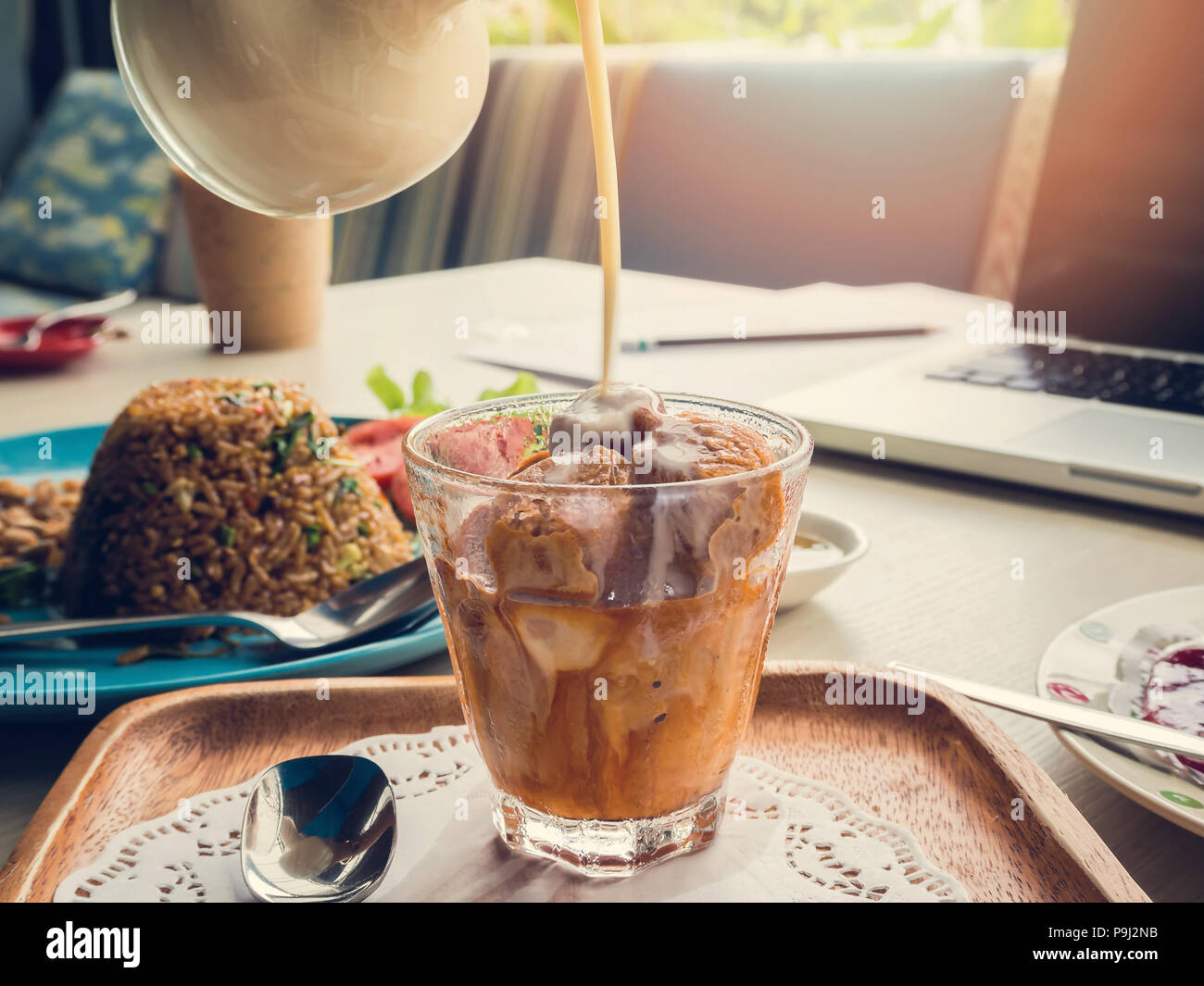 Frozen thai tea was poured with fresh milk Stock Photo - Alamy