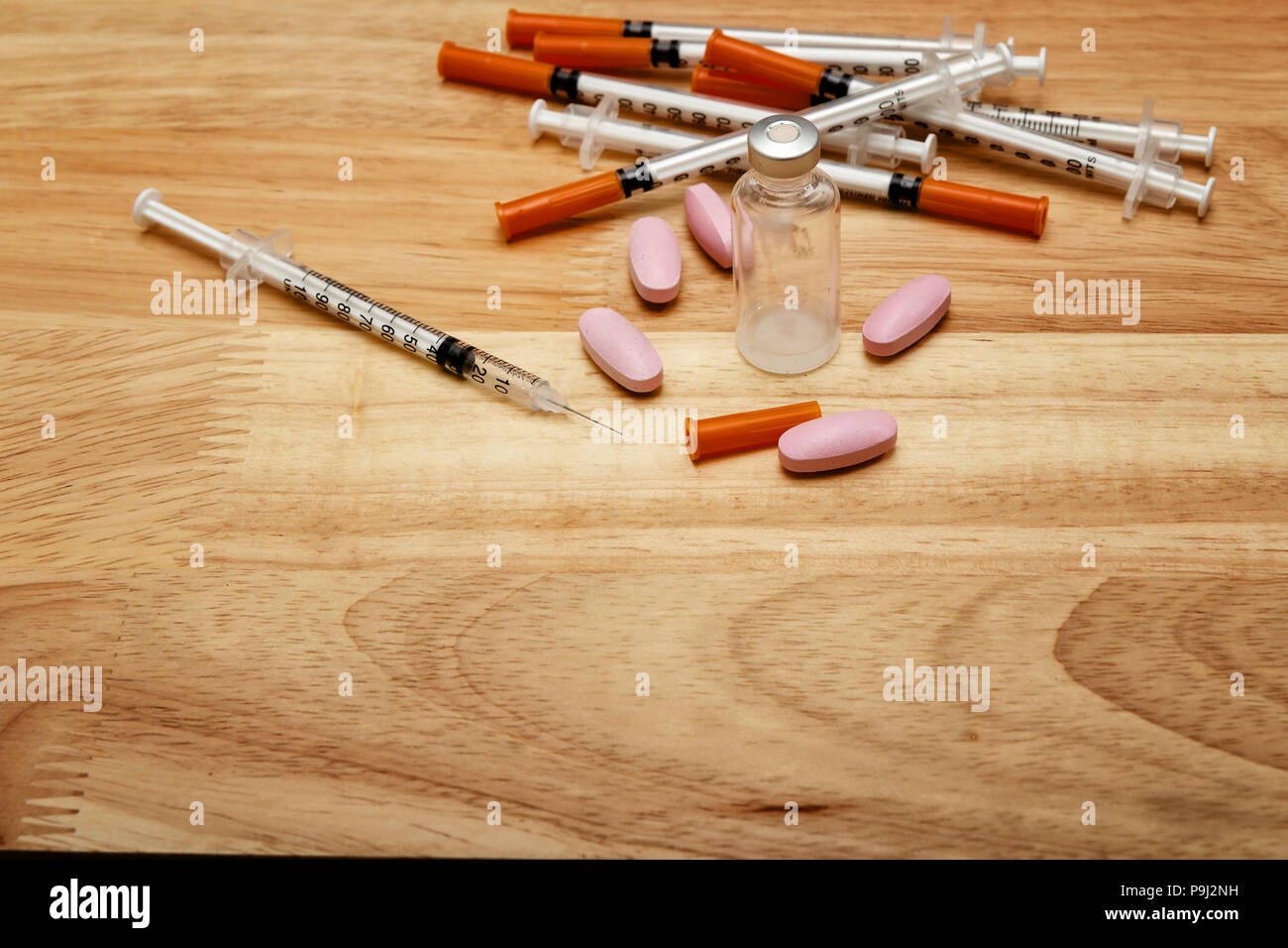 Medical syringe and bottle of potion on wooden desk Stock Photo - Alamy