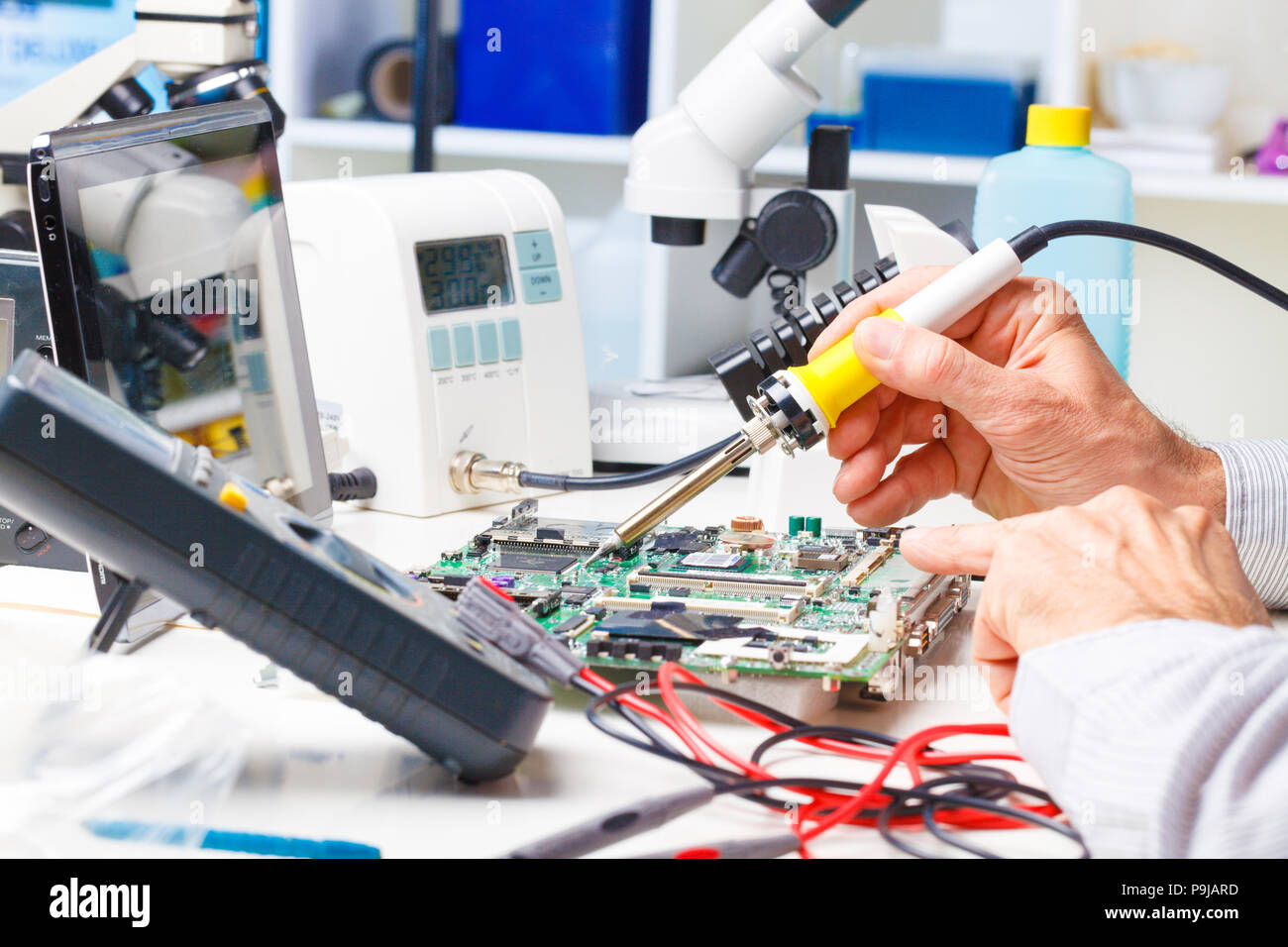 hand men hold tool repairs electronics manufacturing Stock Photo - Alamy