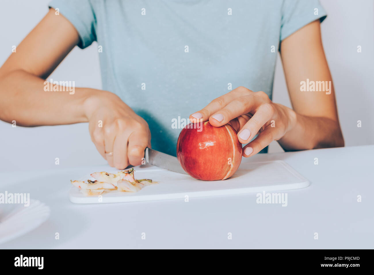 Unrecognizable young woman cutting fruits. Close-up of female's hands ...