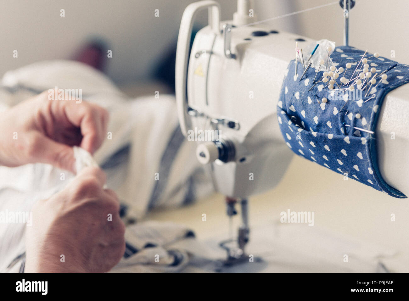 The dressmaker sews at the sewing machine. Workplace of seamstress ...
