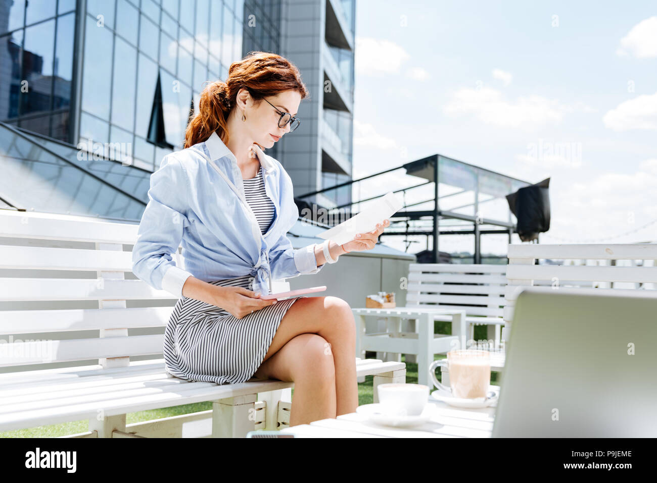 Good-looking fashionable remote worker working on summer terrace Stock ...