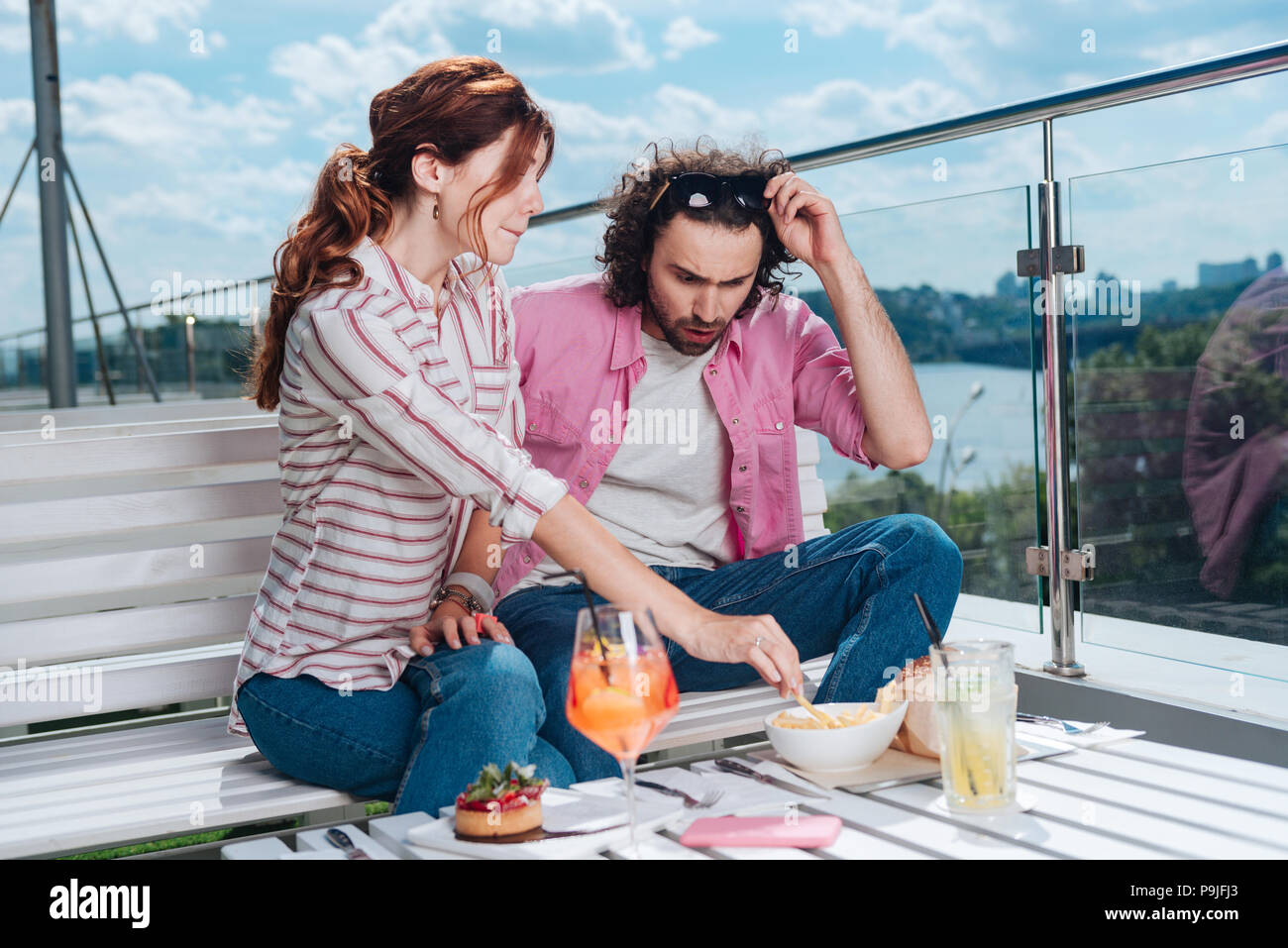 Curly man feeling surprised looking at bad quality of fries Stock Photo ...