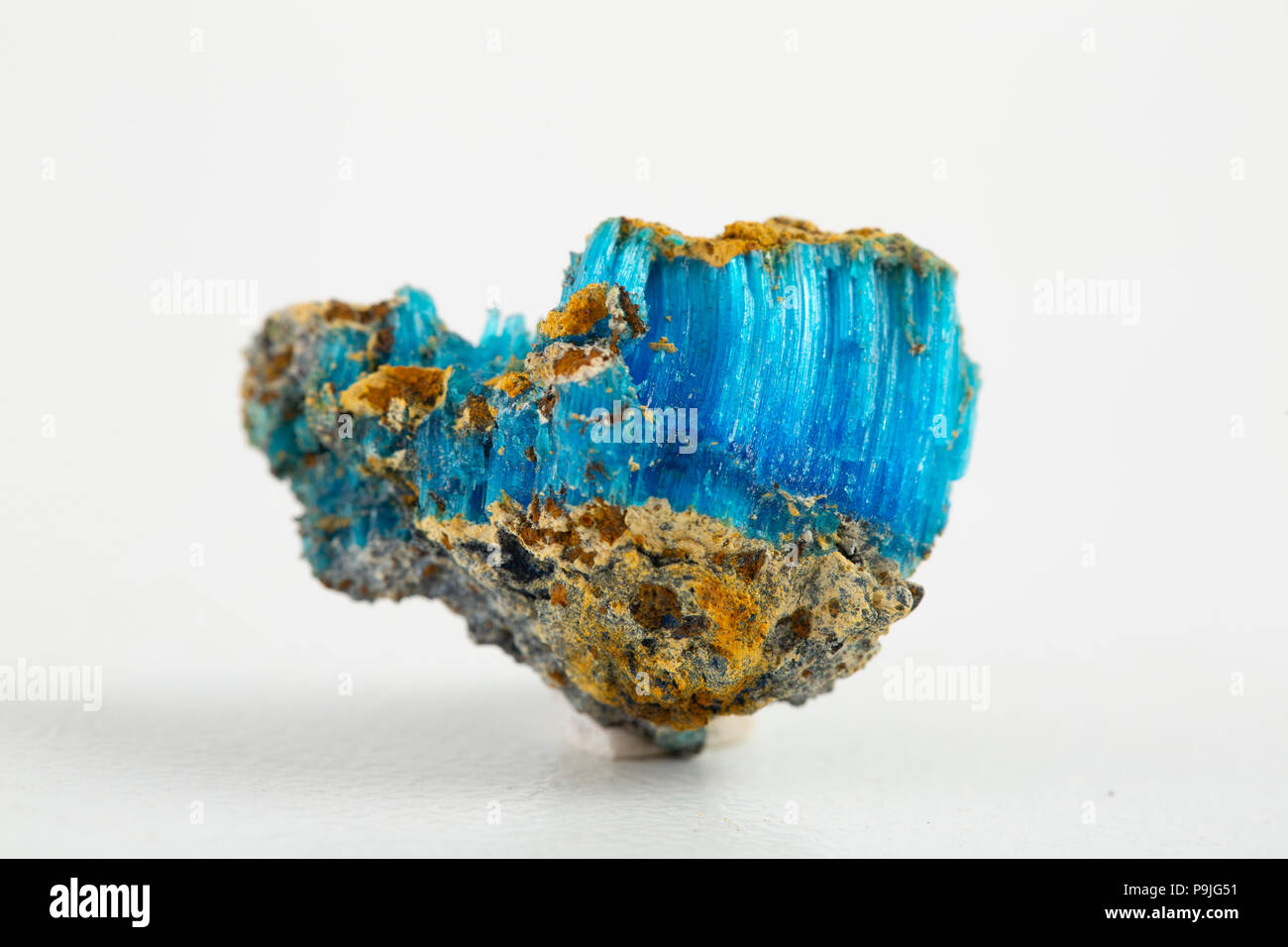 Blue mineral chalcanthite (copper sulfate) on stone on a white ...