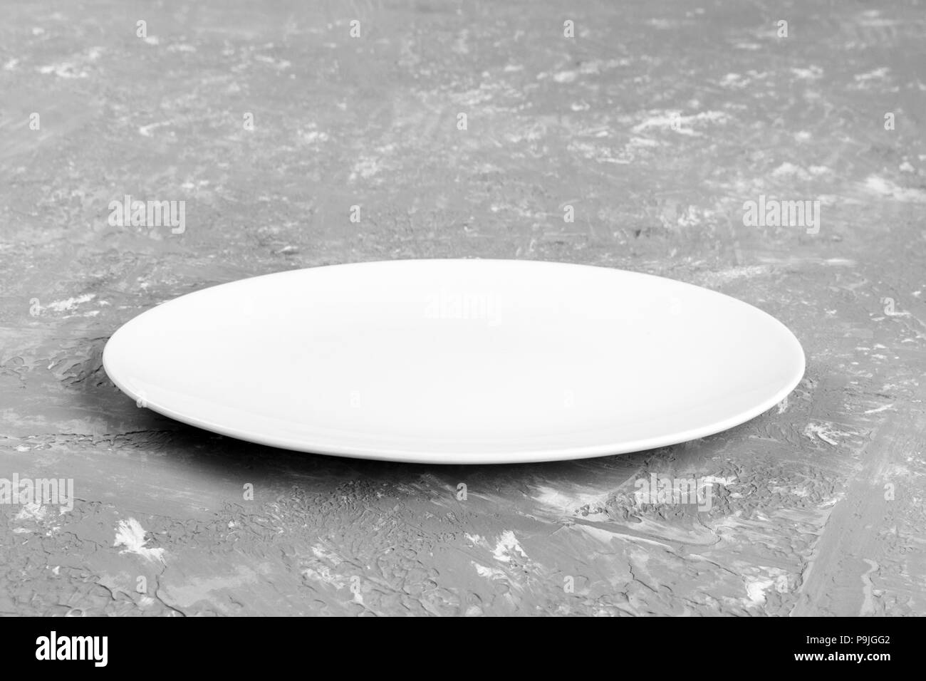 Empty plate on cement background. perspective view Stock Photo - Alamy