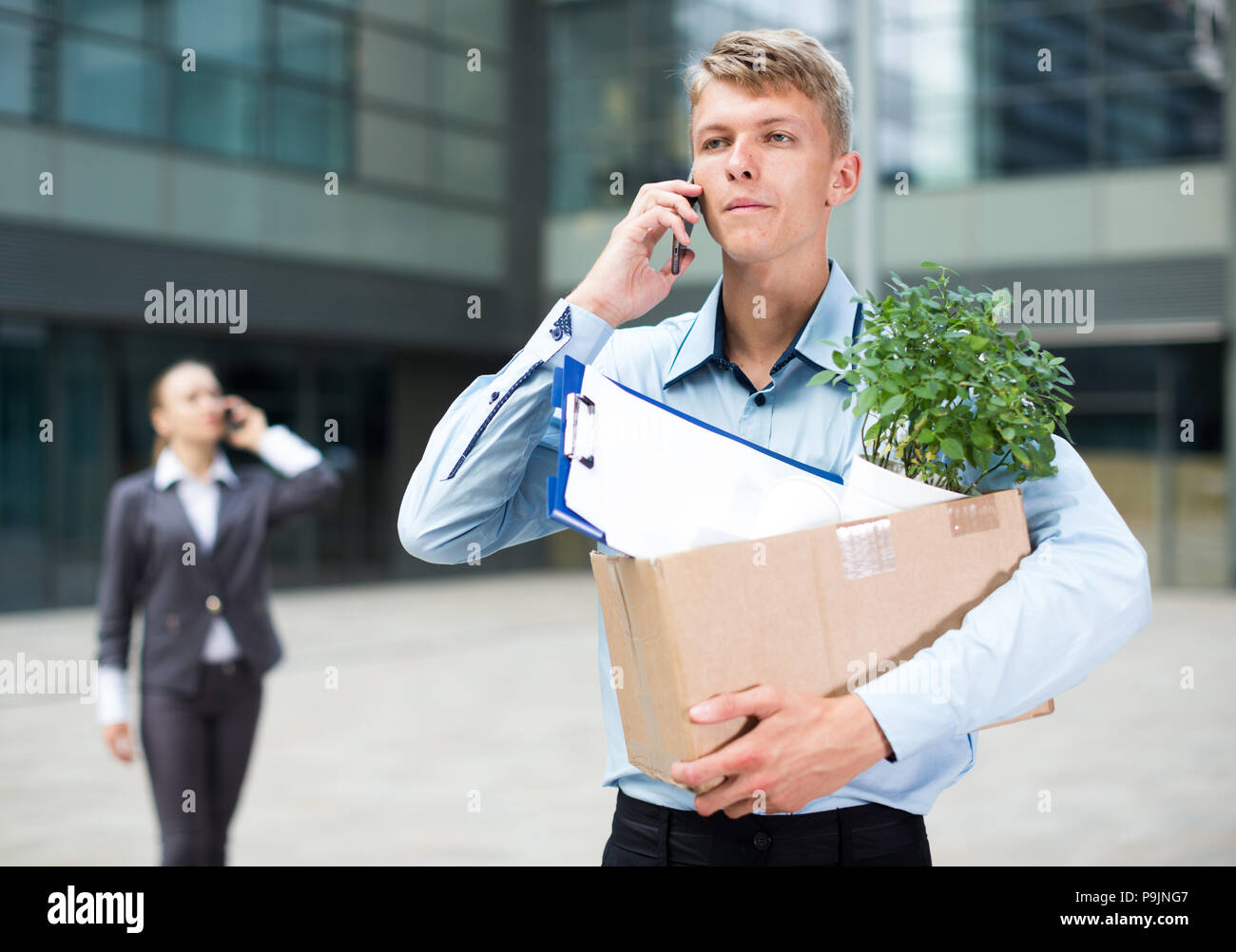Office worker is talking phone about the new job outside the office ...