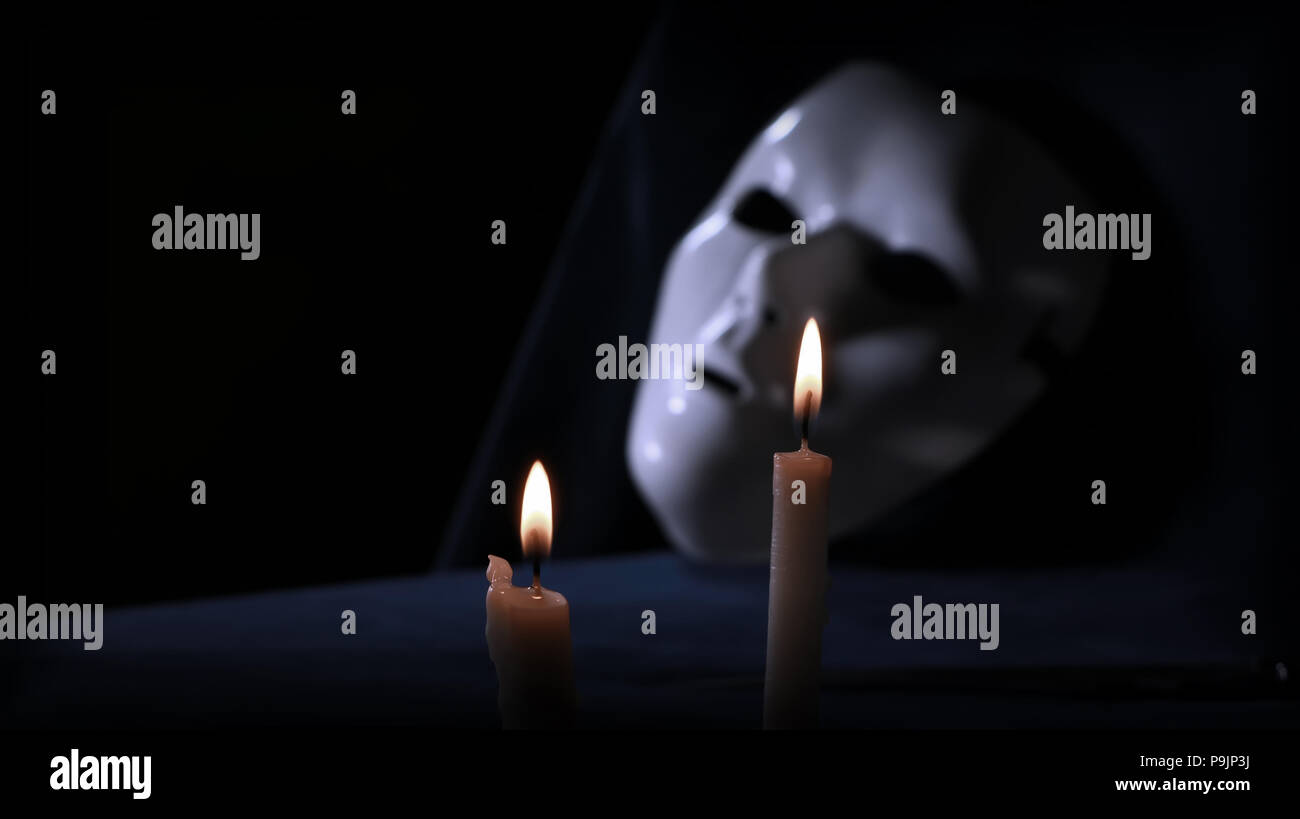 Burning candle fire and mystique mask Stock Photo - Alamy