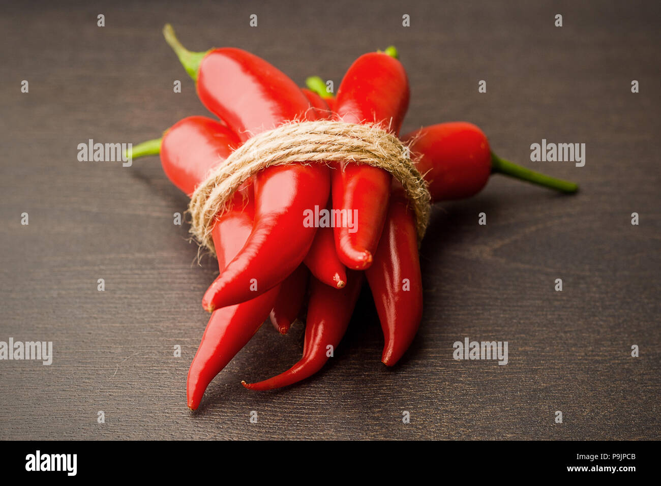 bunch fresh raw red hot chilli pepper on a wooden background tie Stock ...