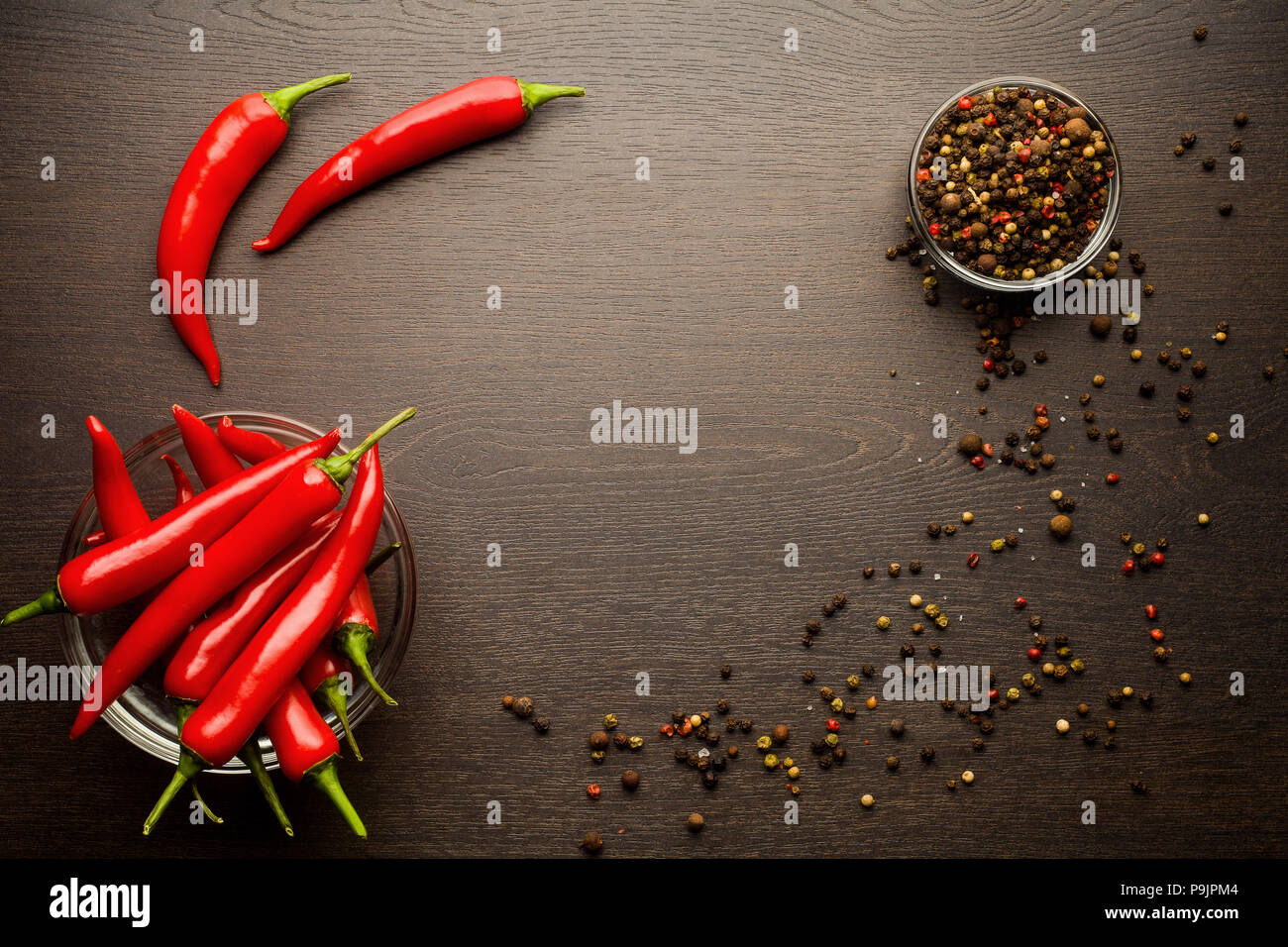 bunch fresh raw red hot chilli pepper and bell pepper on a woode Stock ...