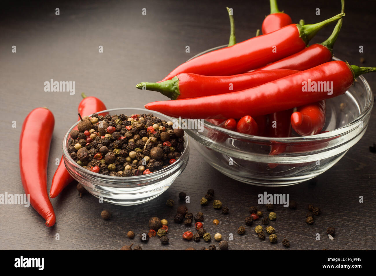 bunch fresh raw red hot chilli pepper and bell pepper on a woode Stock ...
