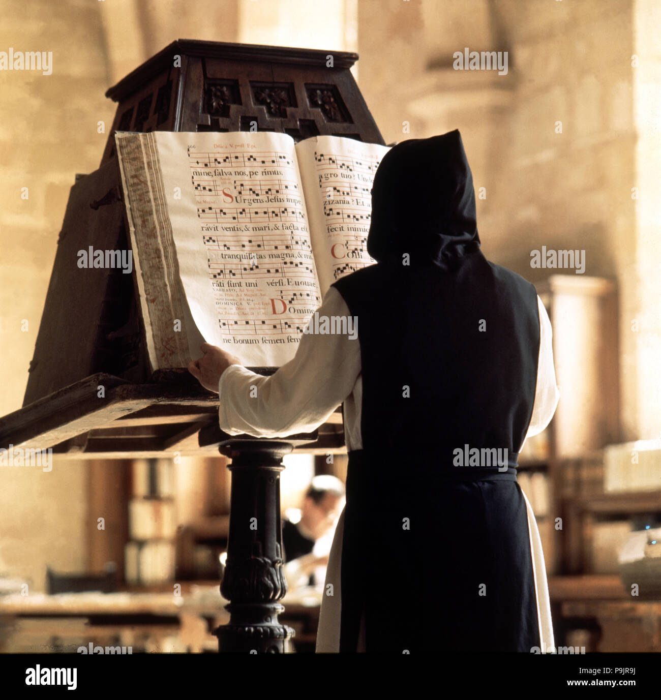 Benedictine monk consulting a song book from the Monastery of Poblet ...