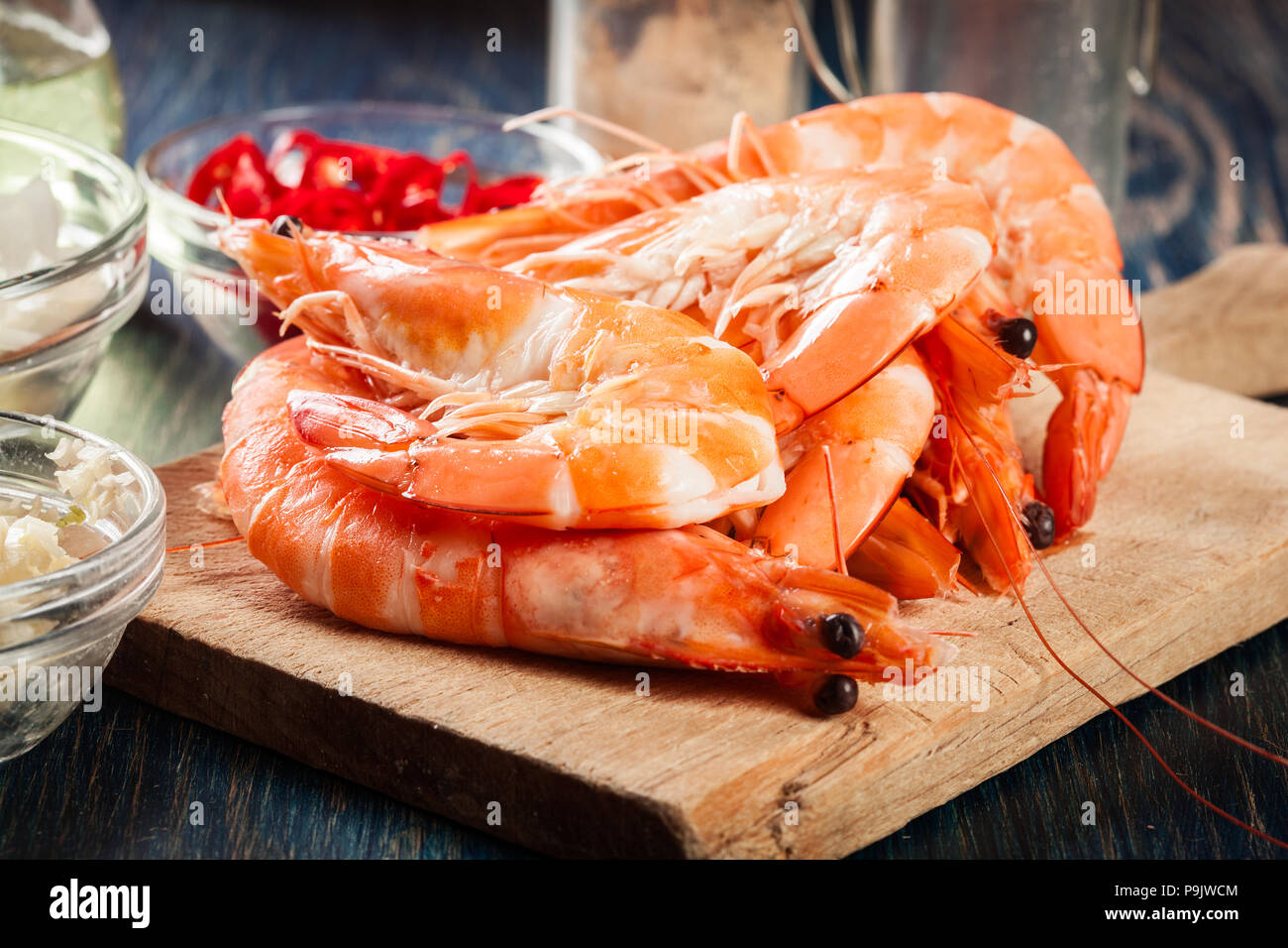 Selection of shrimp ready for frying with onion, garlic, chili and lime ...