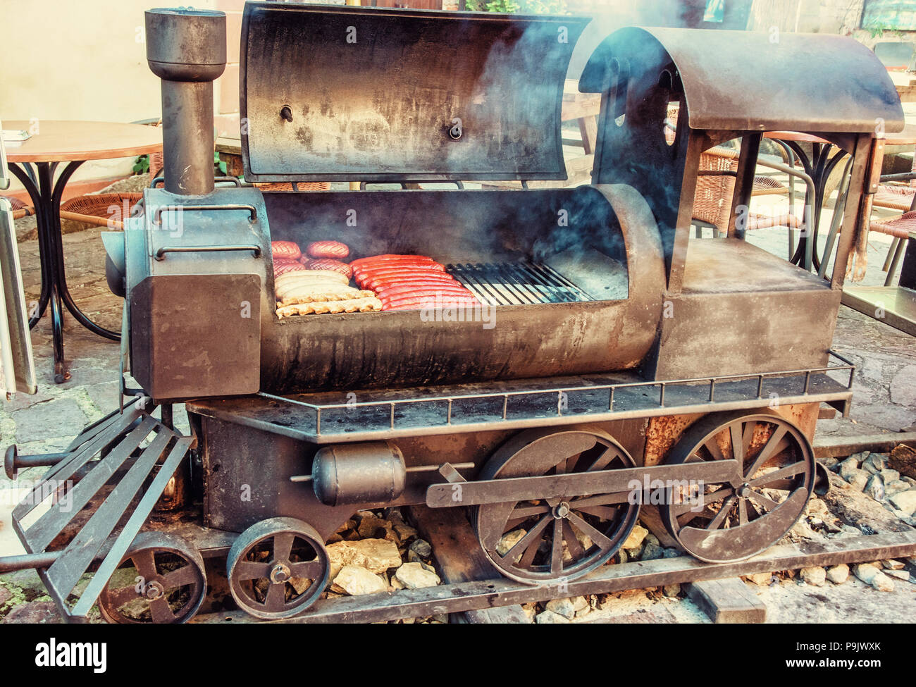 Barbecue grill with meat in shape of old steam locomotive. Bbq scene ...
