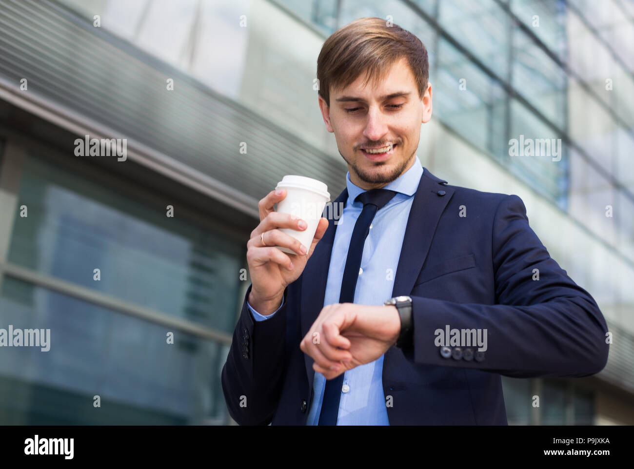 Portrait of cheerful male standing outdoor drinking coffee Stock Photo ...
