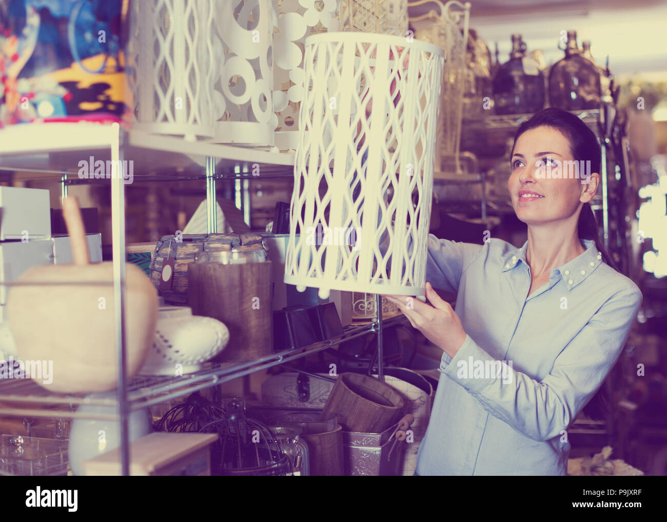 Positive woman customer holding decorative vase in the store Stock ...
