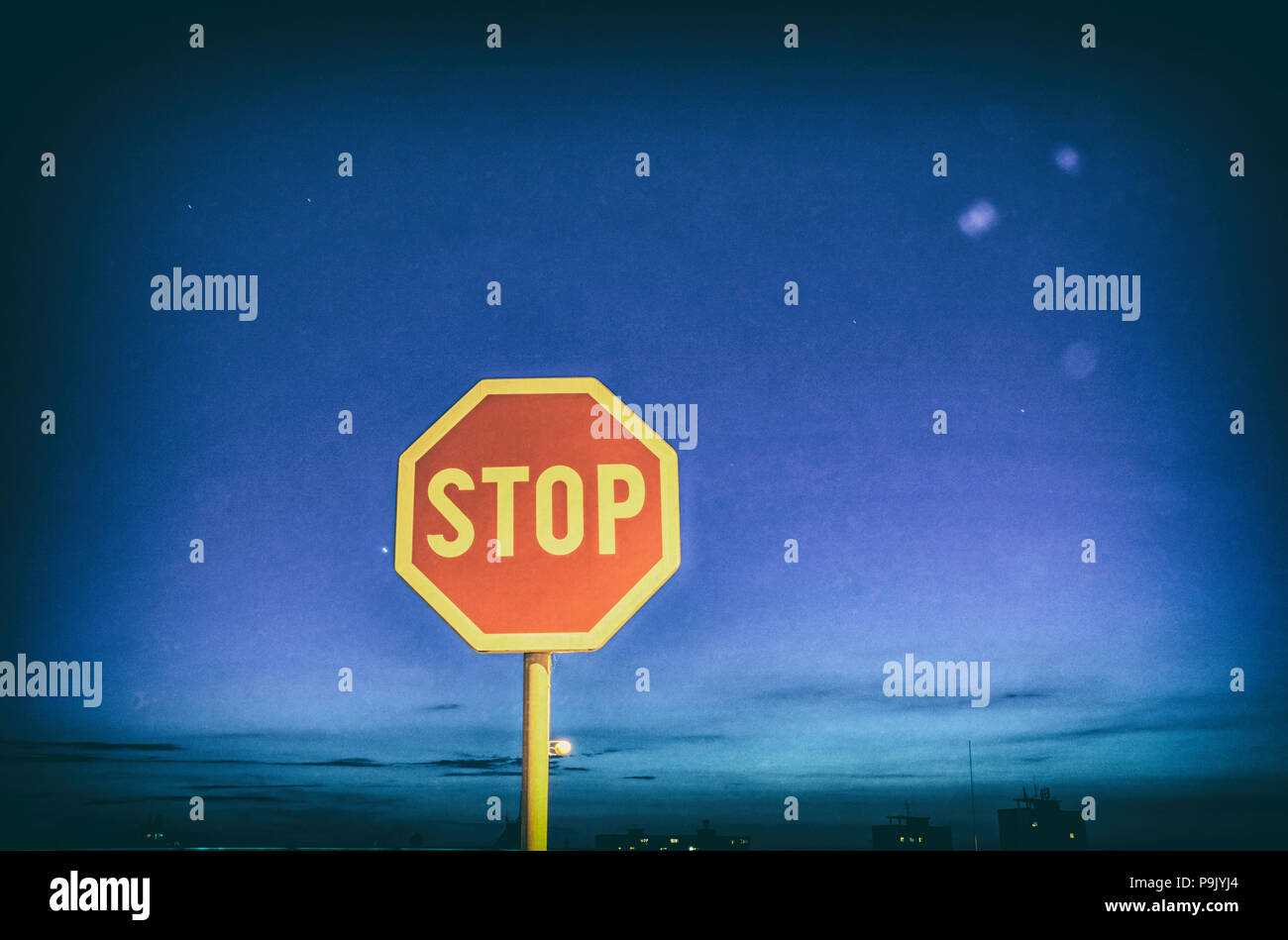 Stop sign in the night city. Traffic regulation. Blue sky. Analog photo ...