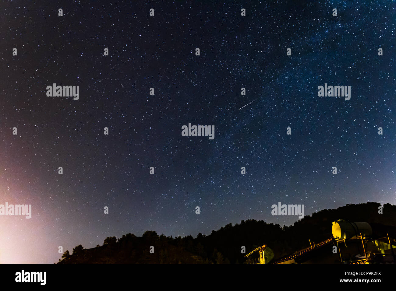 Stars and falling star over the forest and a house at the Troodos ...