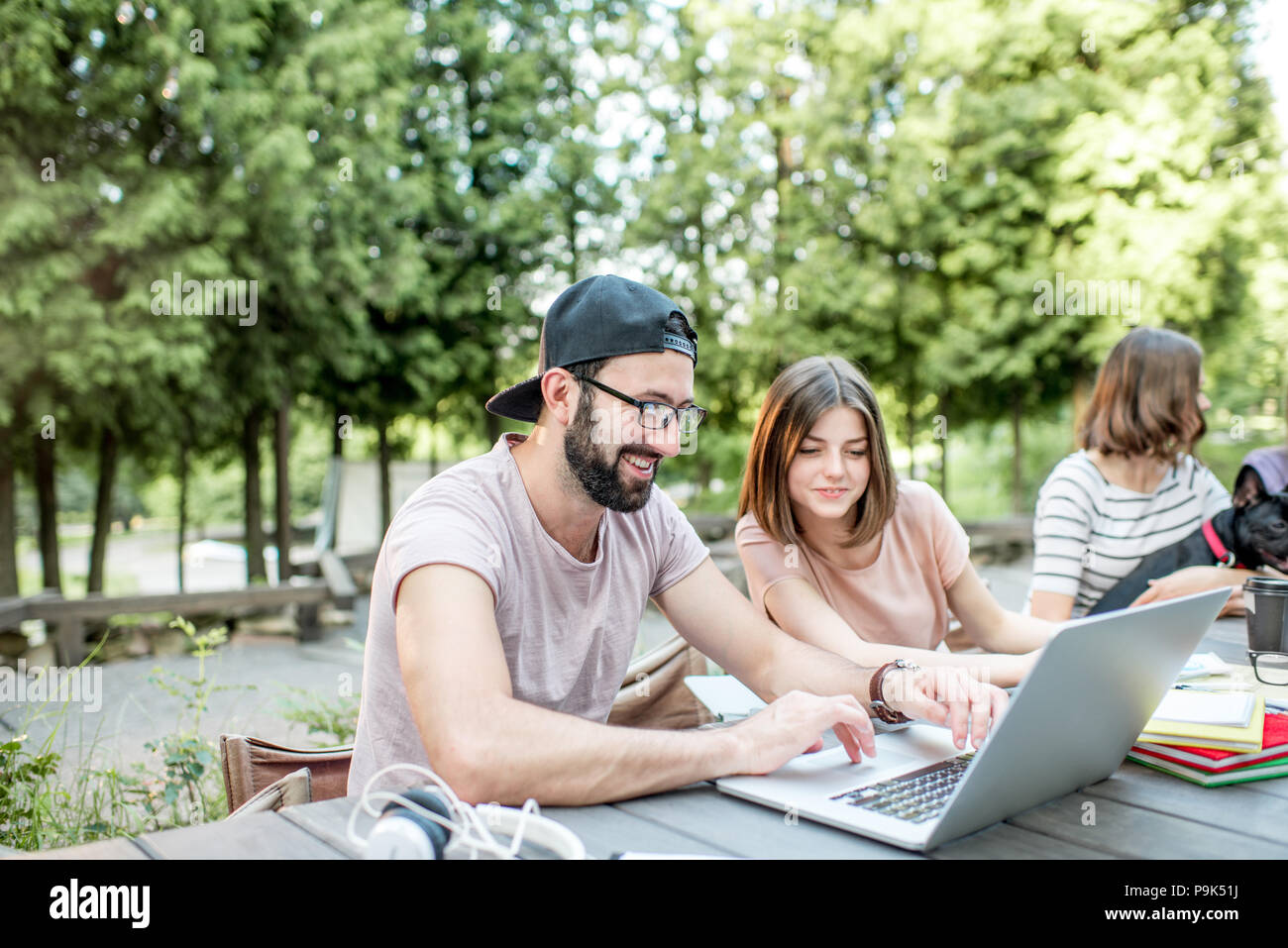 Young people working at the outdoor cafe Stock Photo - Alamy