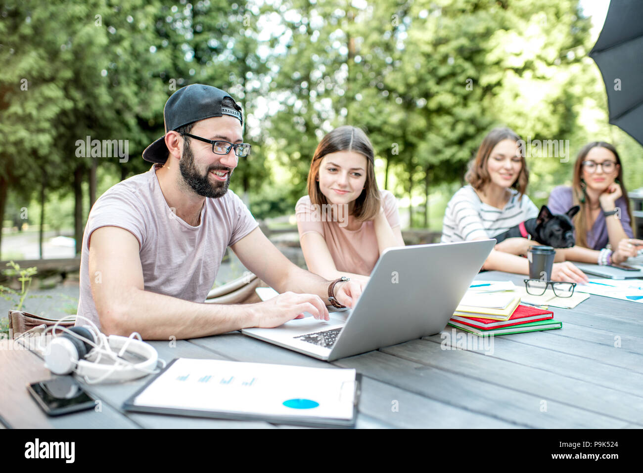 Young people working at the outdoor cafe Stock Photo - Alamy