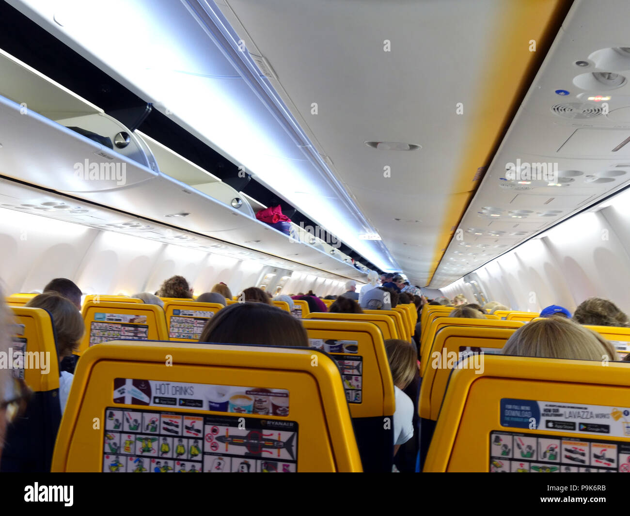 Airplane cabin with small plane seating, a few people take their ...