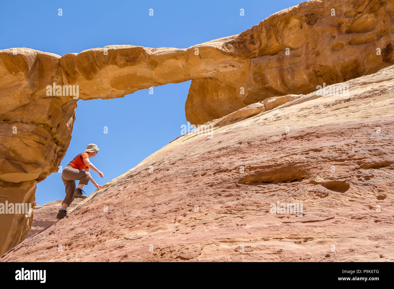 WADI RUM DESERT, JORDAN - APRIL 30, 2016: Woman climbing to the Burdah ...