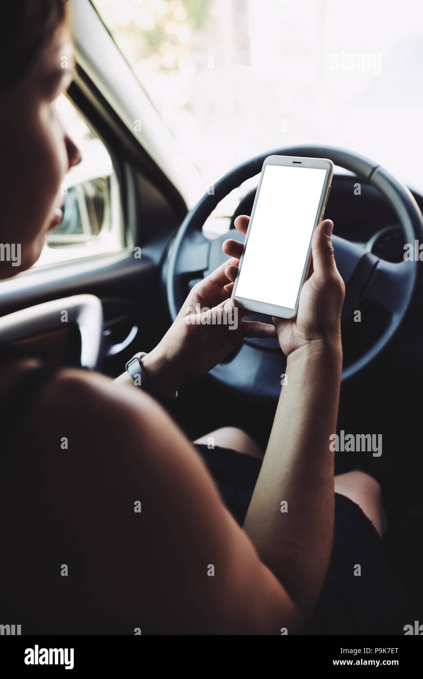 Woman looking at the screen of the smartphone in the car Stock Photo ...