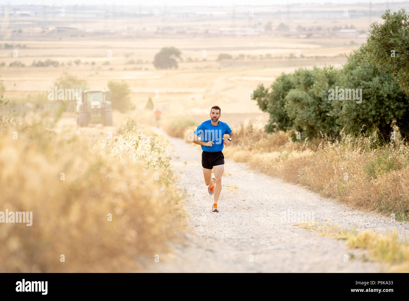 Fitness runner running extreme cross country and training on rural ...