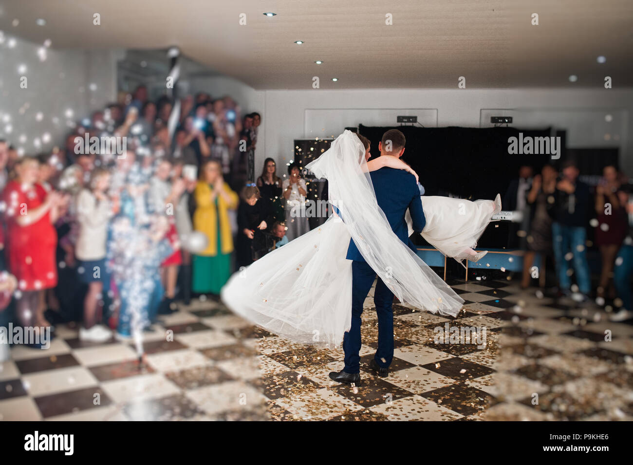 Gorgeous wedding couple performing their first dance with confetti ...
