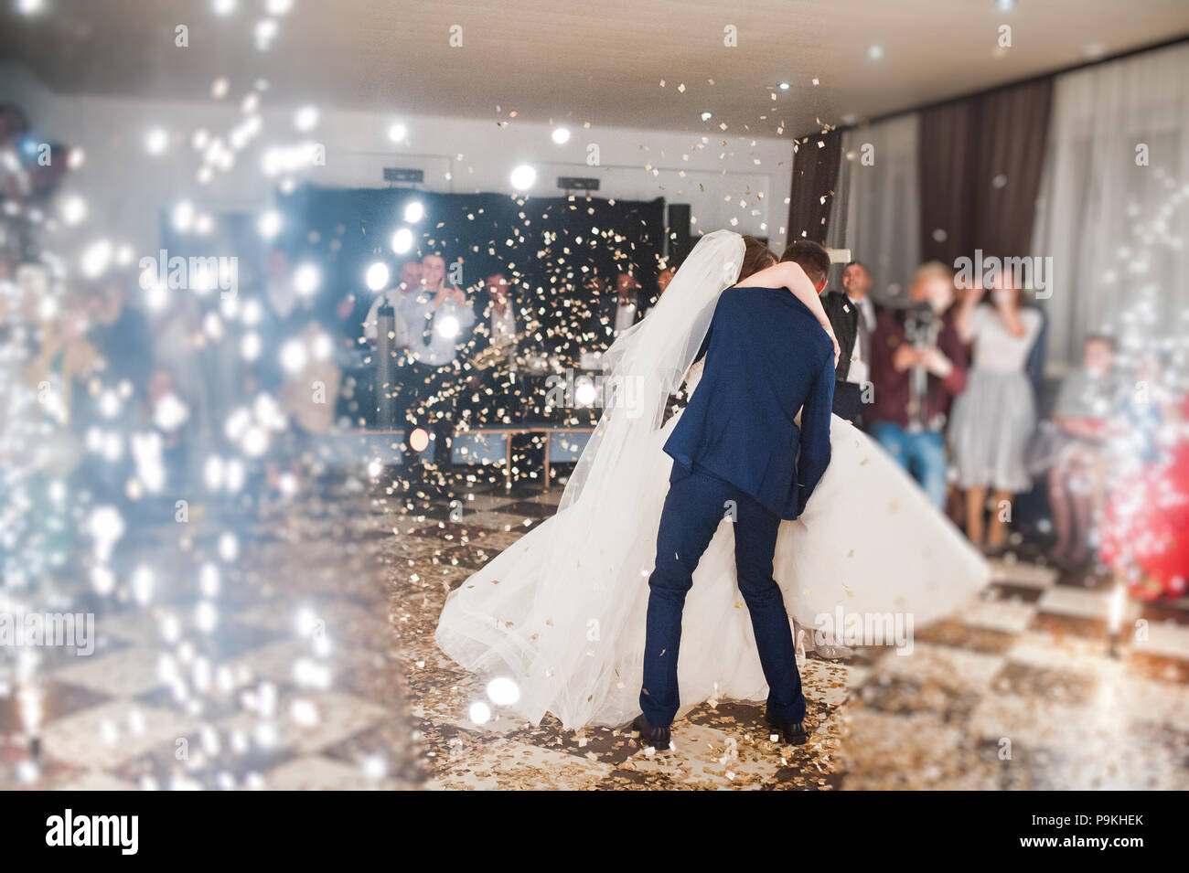 Gorgeous wedding couple performing their first dance with confetti ...