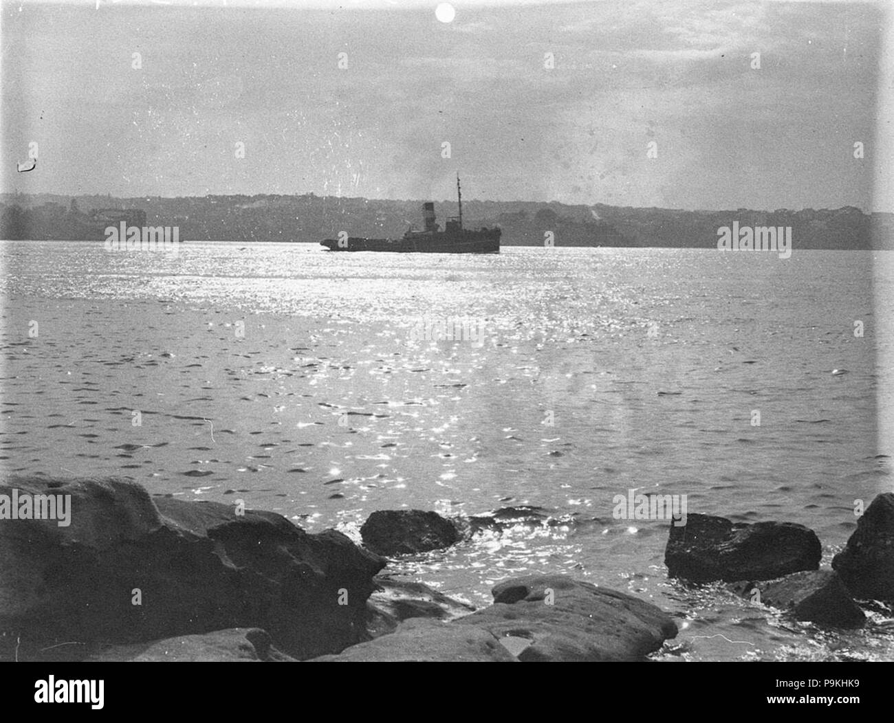 273 SLNSW 51643 A backlighted scene of tug boat waiting to take a ship ...