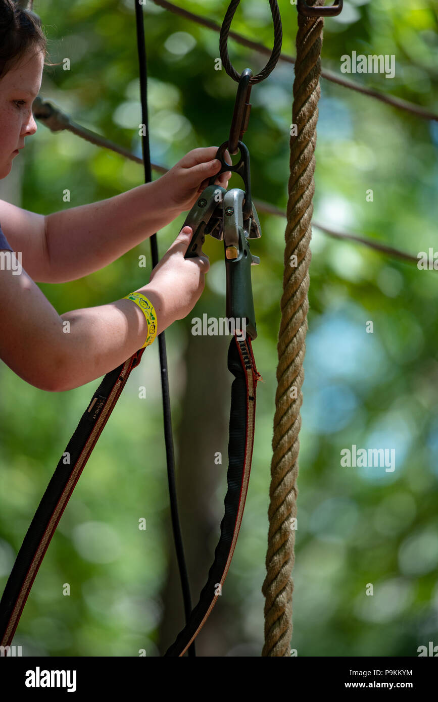 Portrait of a beautiful girl on a rope park among trees. Children ...
