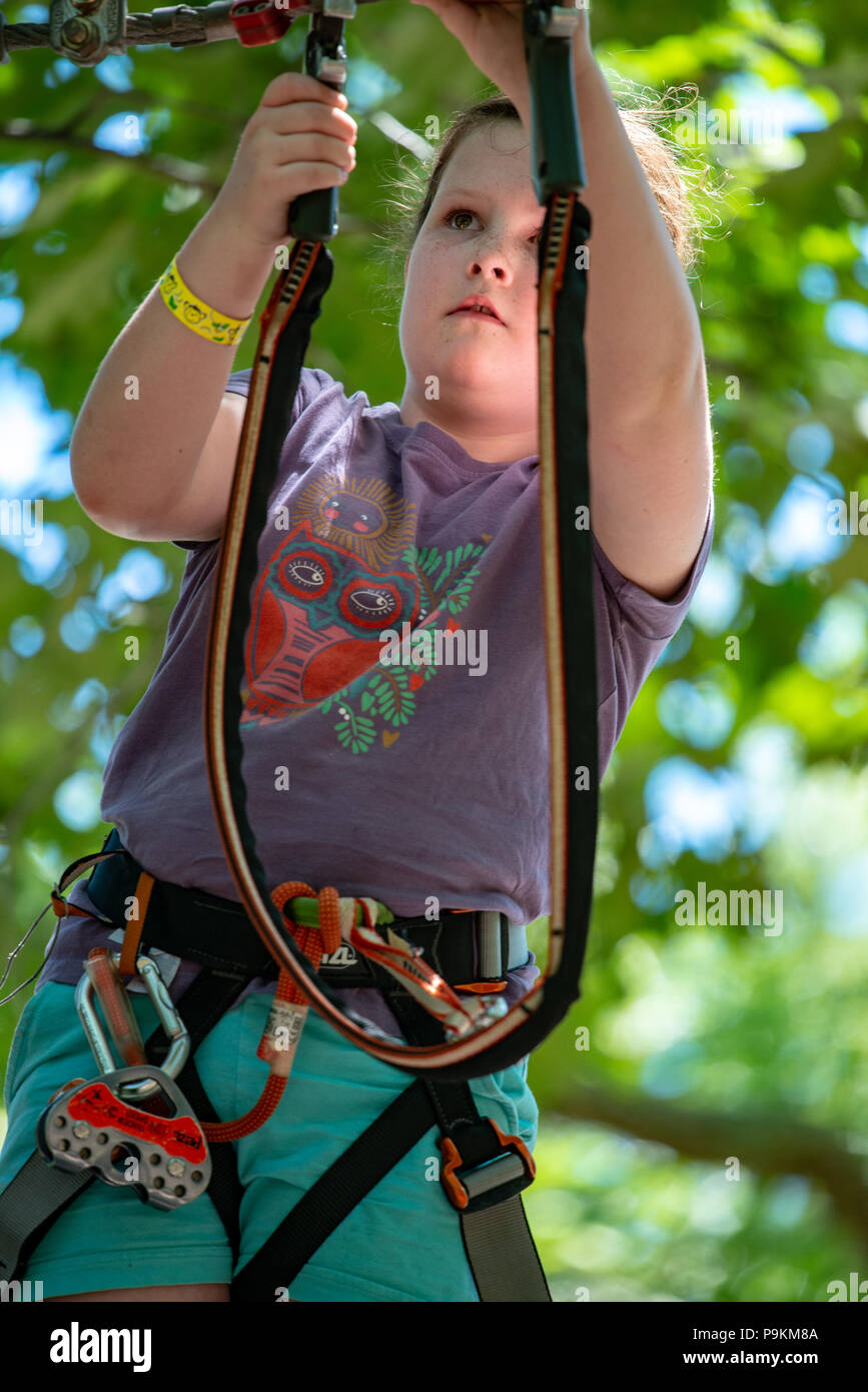 Portrait of a beautiful girl on a rope park among trees. Children ...