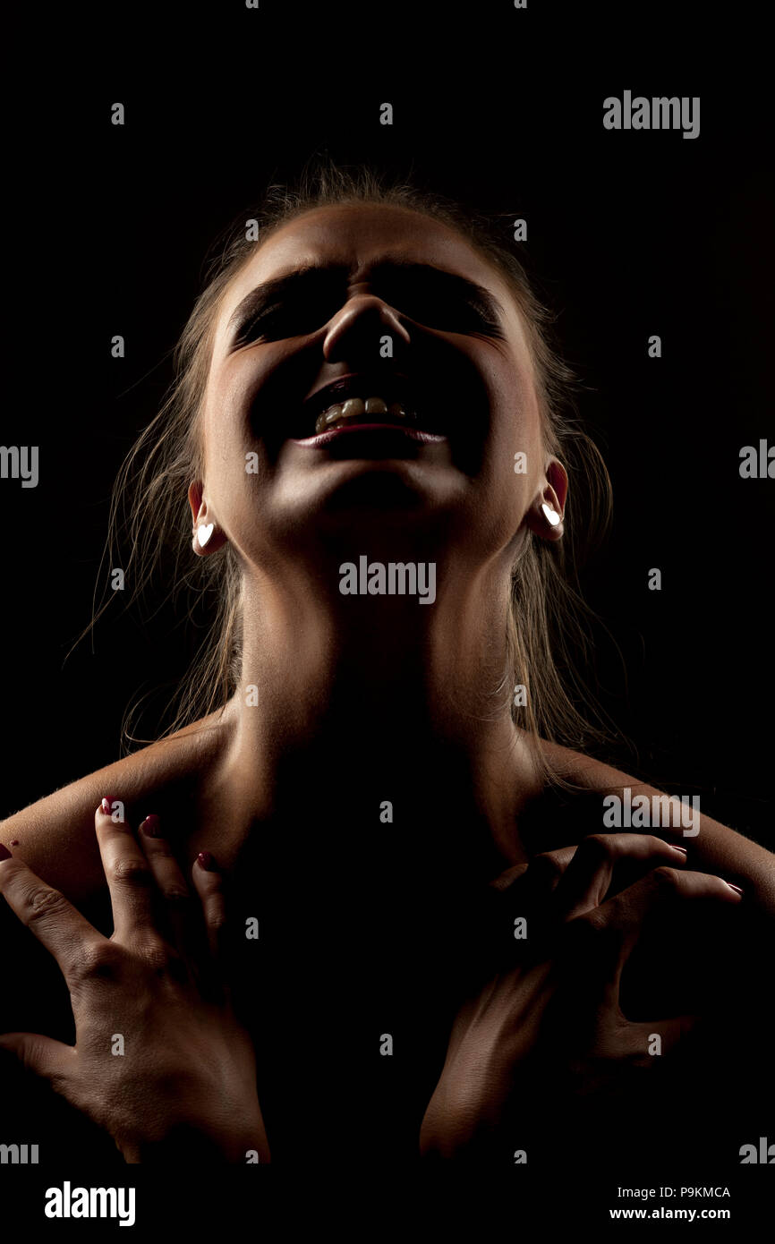 portrait of screaming woman in shadow on dark background Stock Photo ...