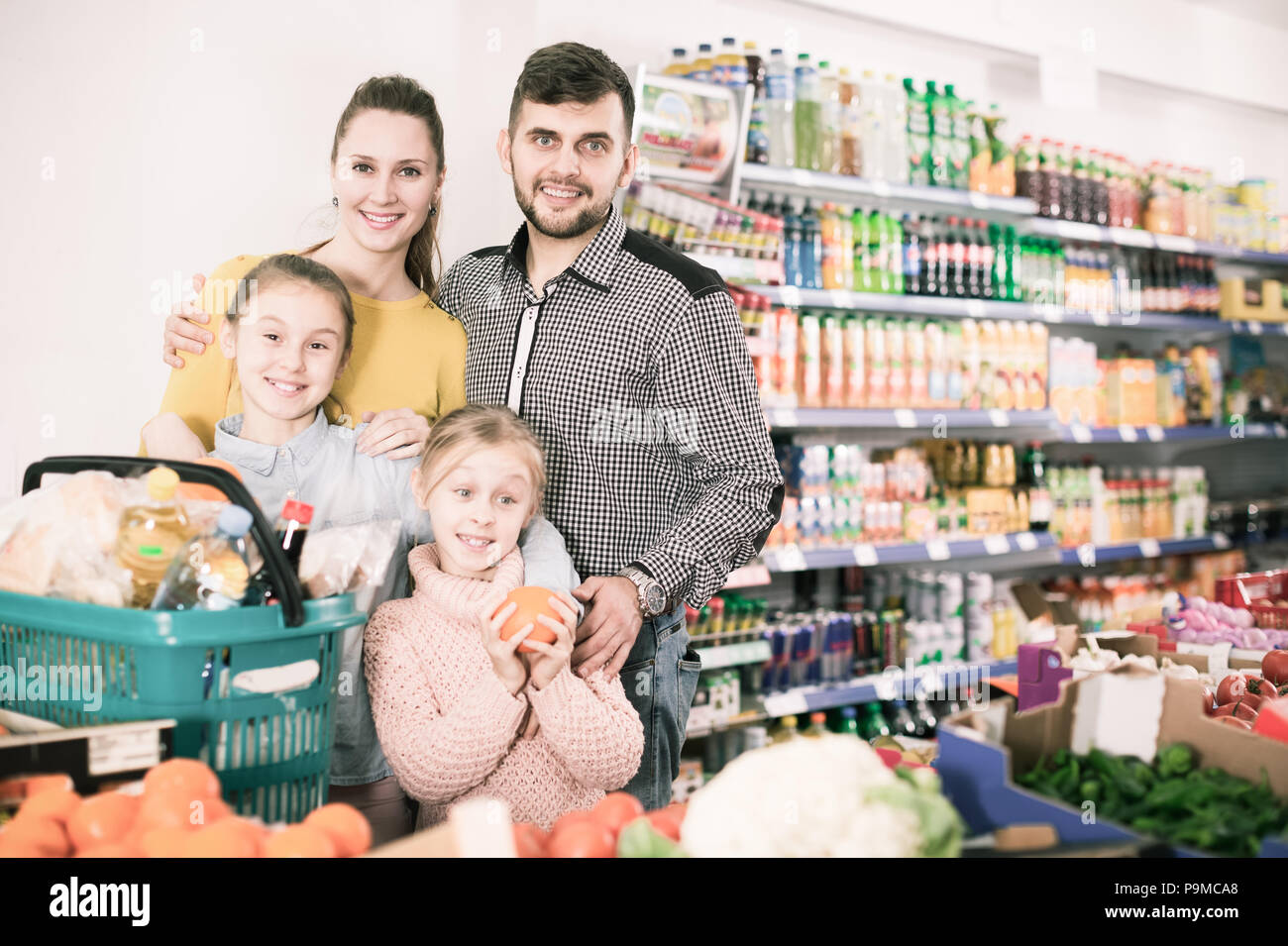 Cheerful family shoppers during family shopping in vegetable department ...