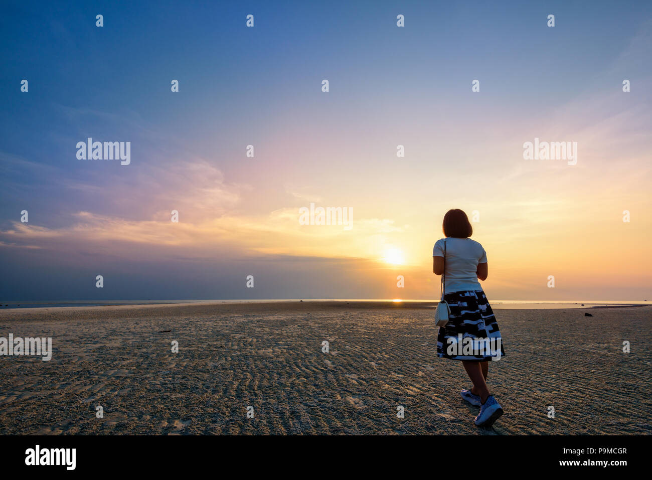 Young woman strolling on beach hi-res stock photography and images - Alamy
