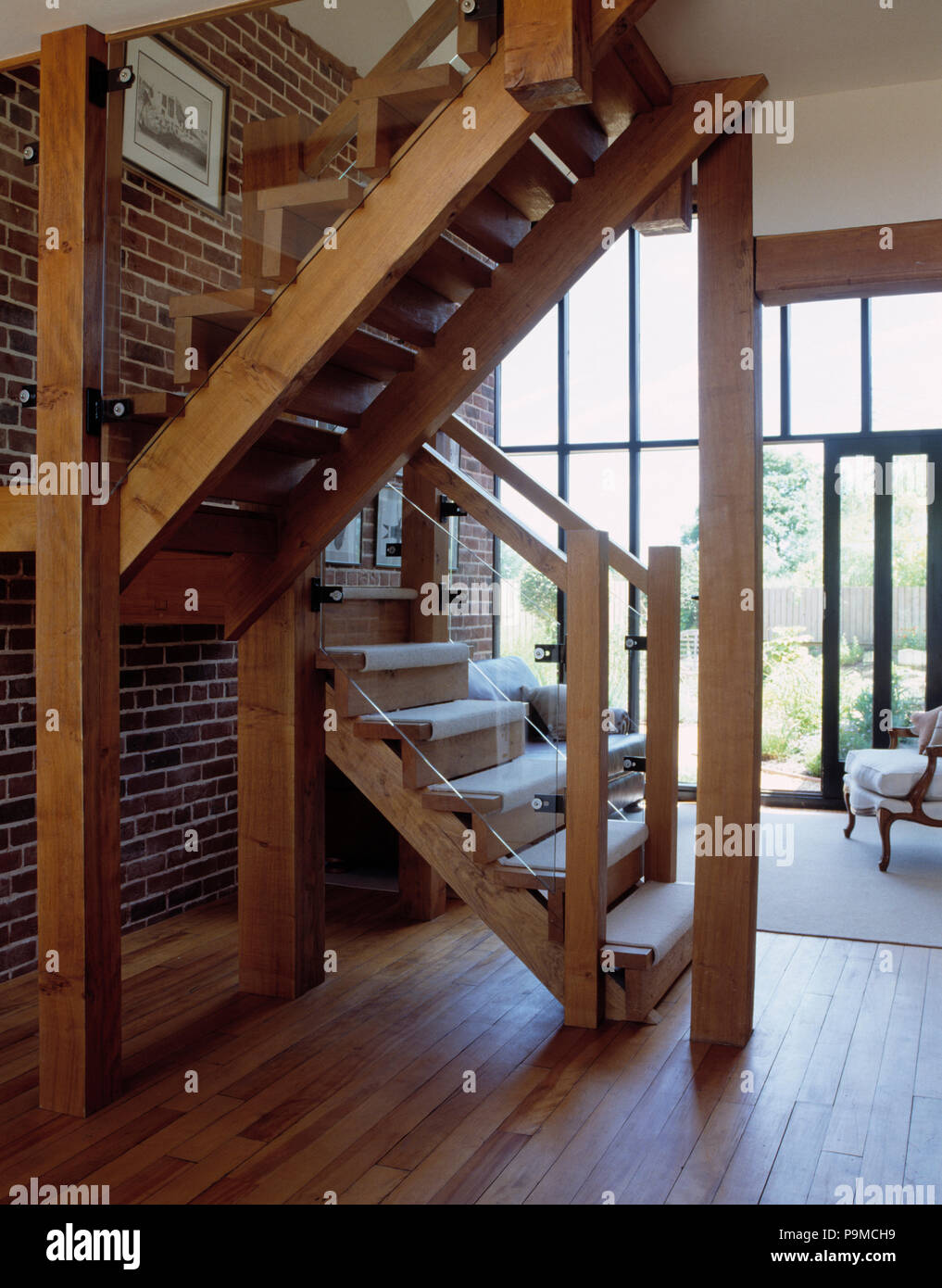 Wooden staircase in hall with wooden flooring in barn conversion with ...