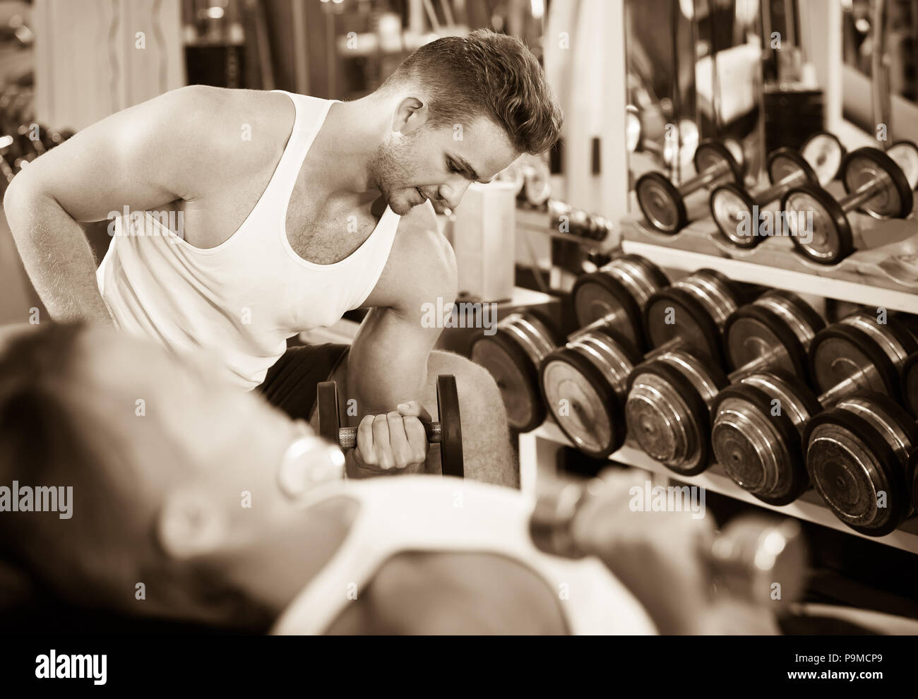 well trained happy spanish man training hands using heavy weight ...