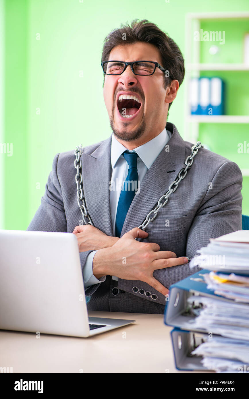 Employee chained to his desk due to workload Stock Photo - Alamy