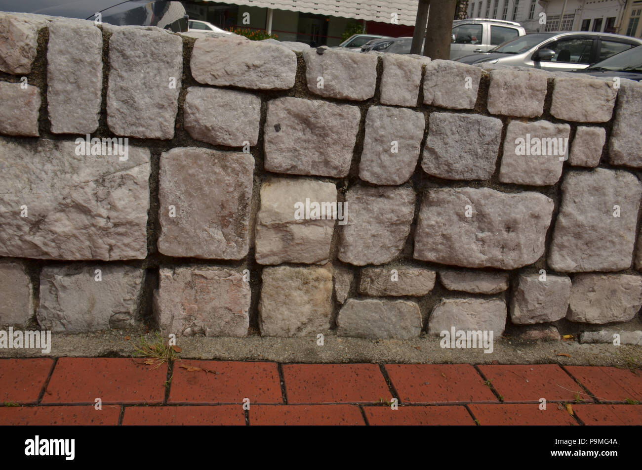 A neatly crafted wall, made of various sized and dressed stone blocks ...