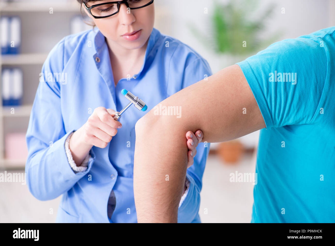 Doctor checking nerve reflexes with hammer Stock Photo - Alamy