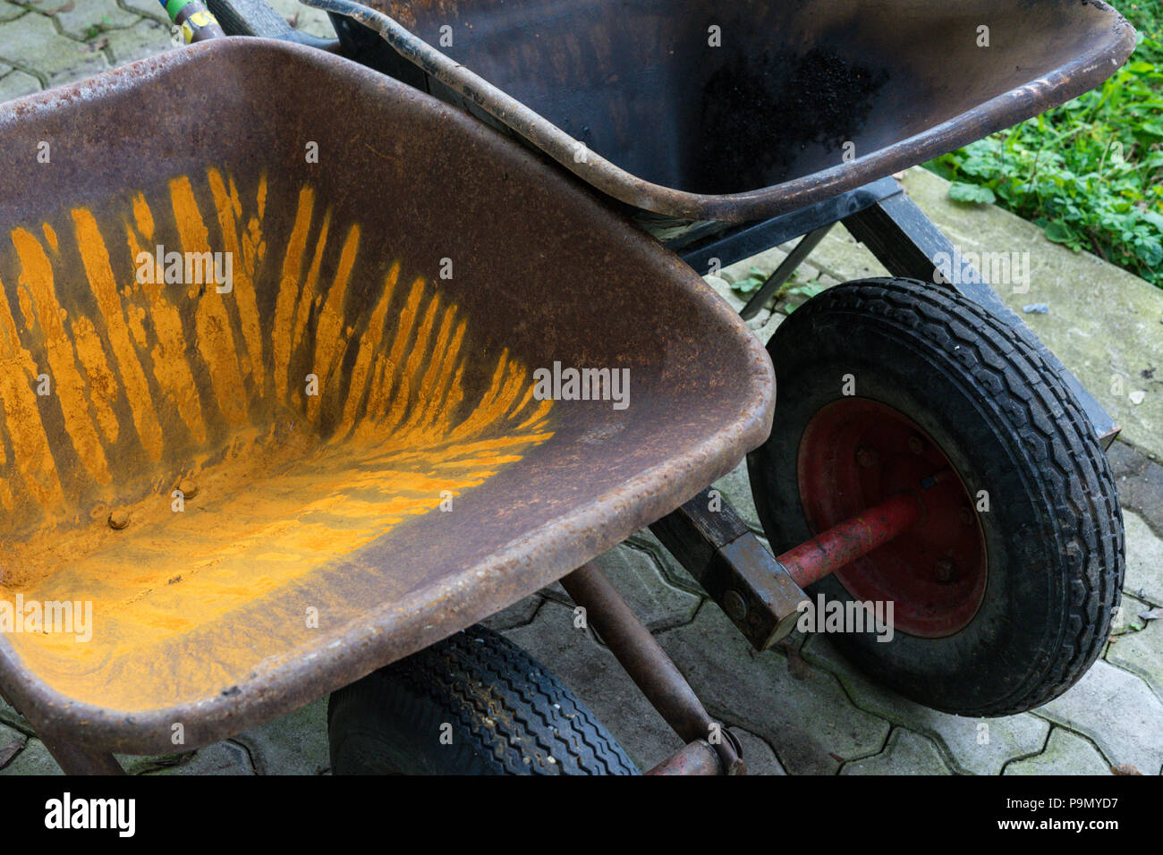 empty wheelbarrow for gardening and construction work with yellow paint ...