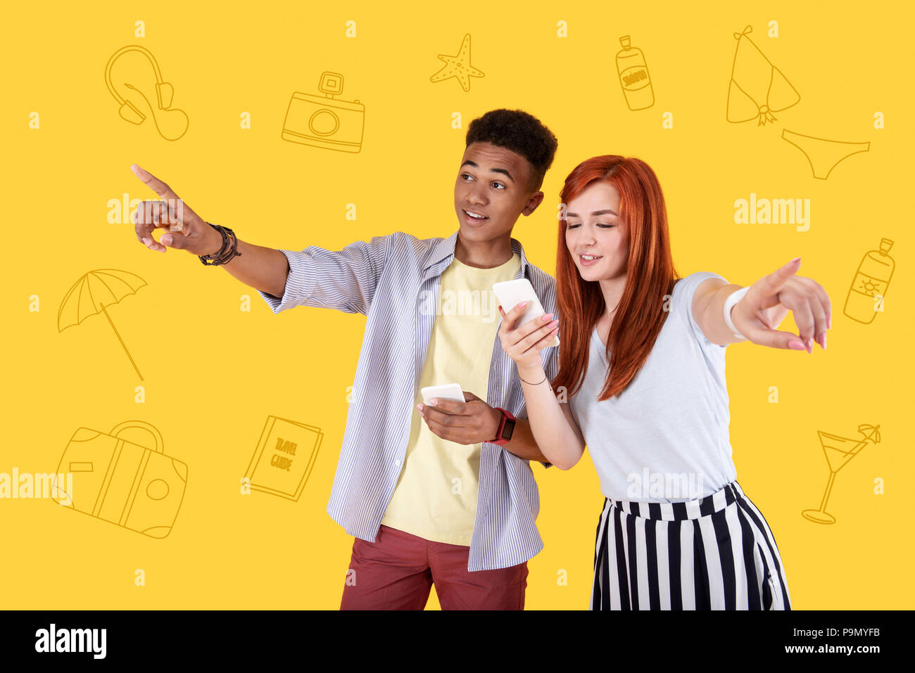 Cheerful students smiling and pointing to different directions Stock ...