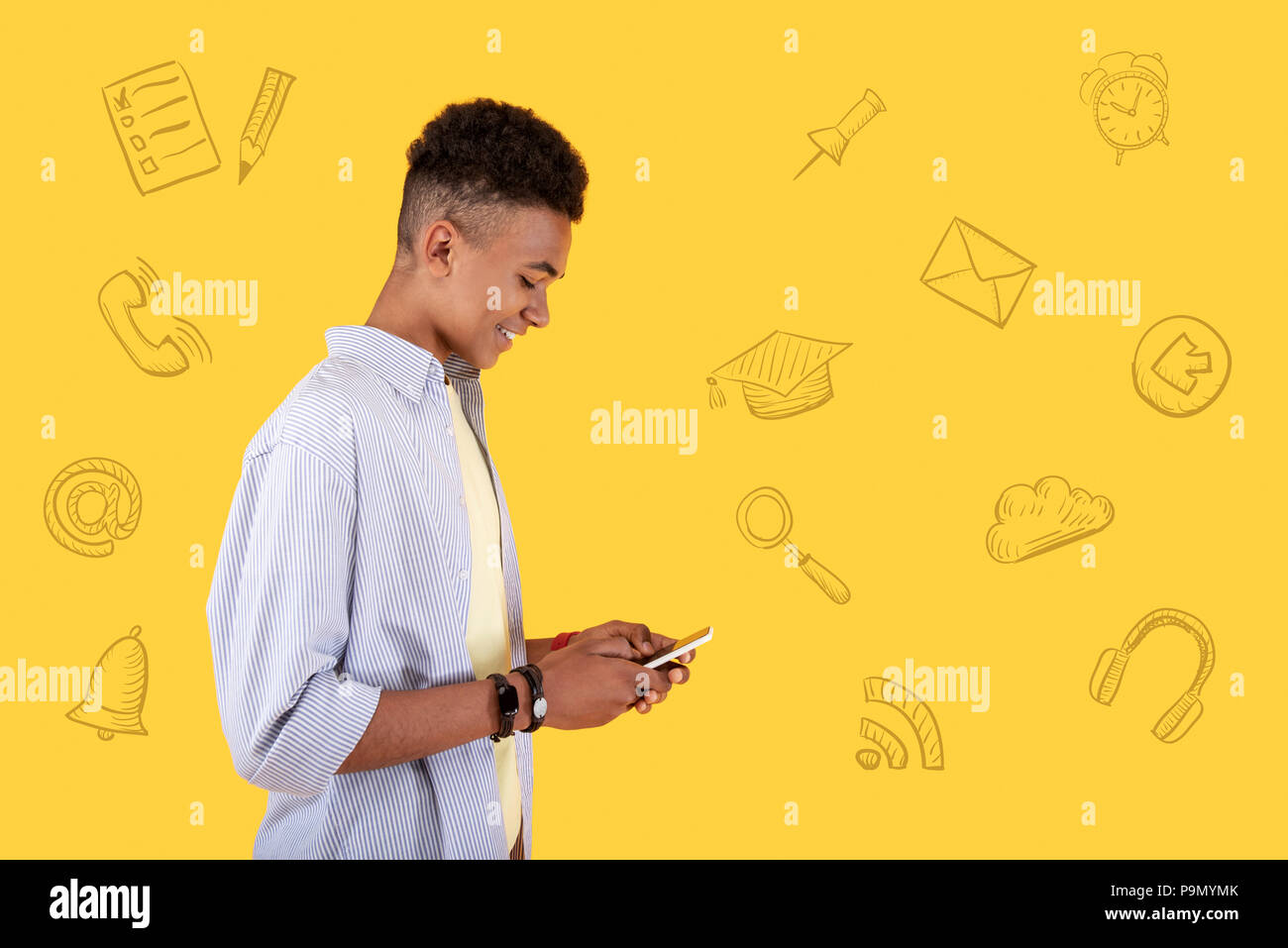 Smiling blogger typing messages to his followers and looking glad Stock ...