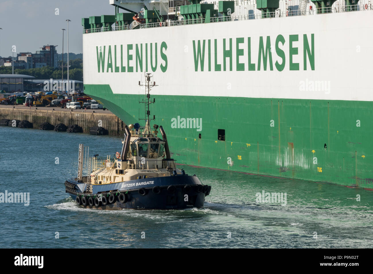 car transporter ship in the port of southampton with a tug boat Stock ...