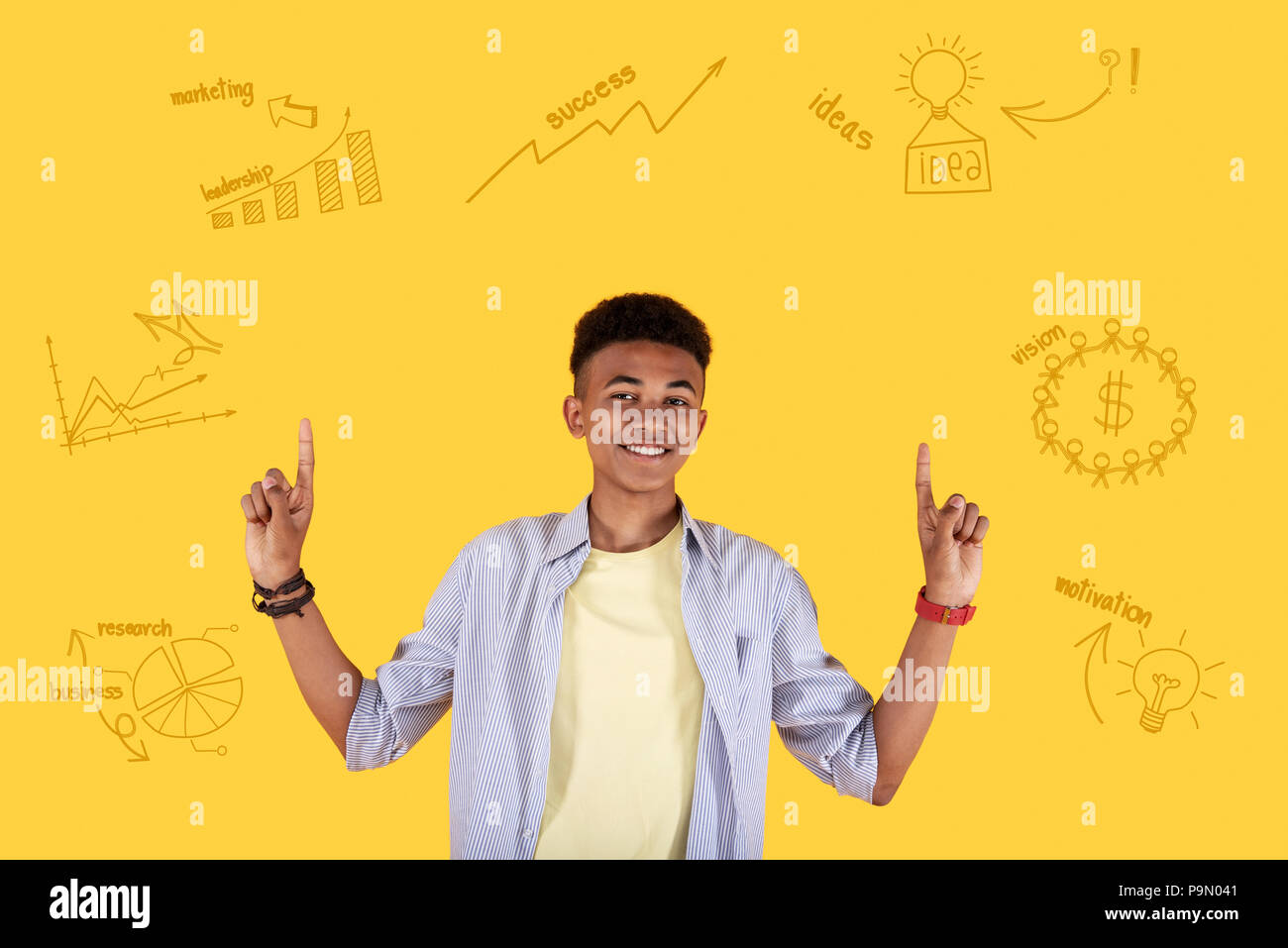 Cheerful student pointing his fingers up and showing the results of his ...