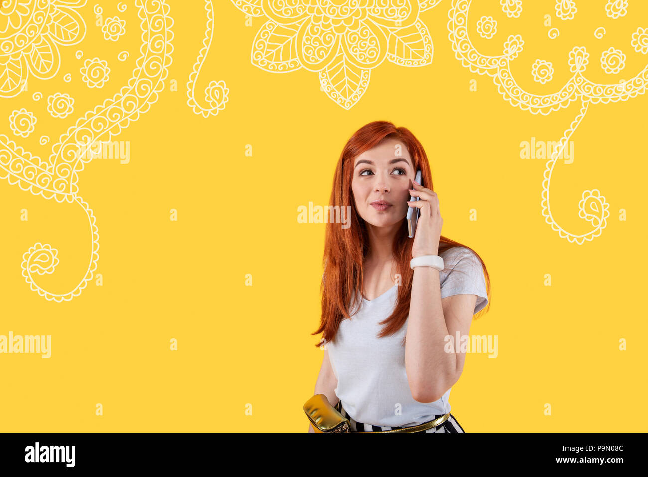 Pretty girl looking interested while talking on the phone Stock Photo ...